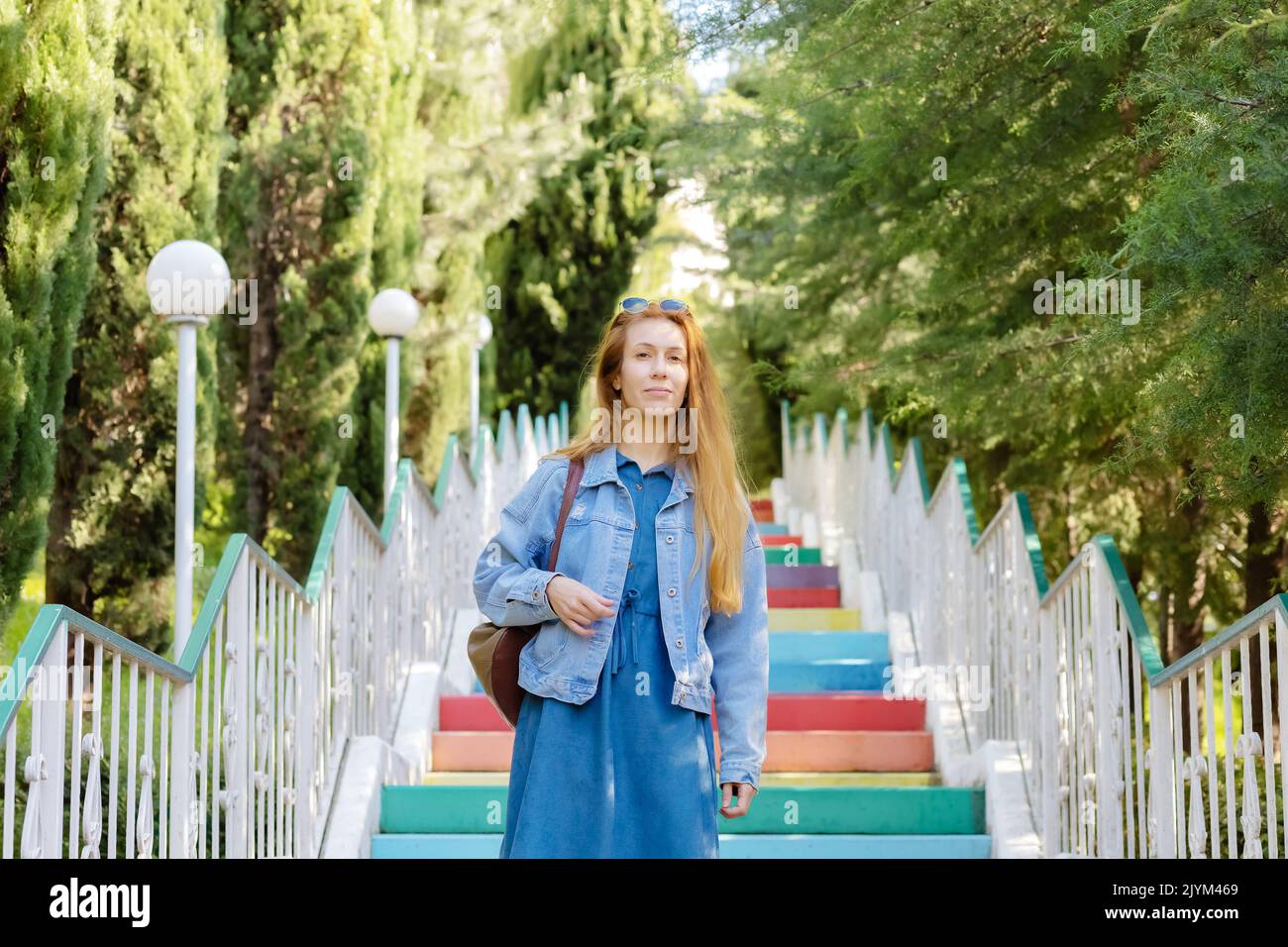 Woman on multi-colored steps. Concrete colored staircase. Blonde girl ...