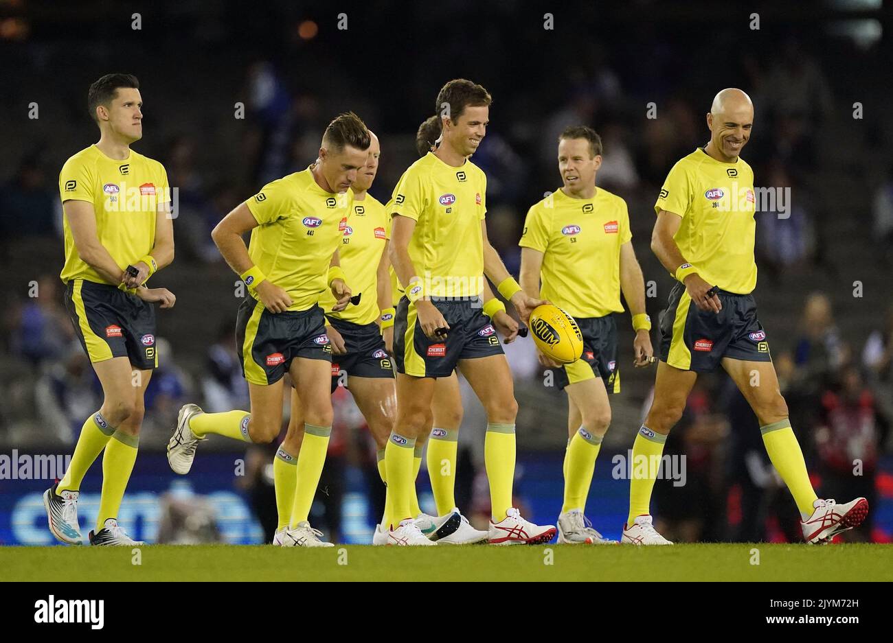 The umpires walk onto the field during the Round 1 AFL match between ...