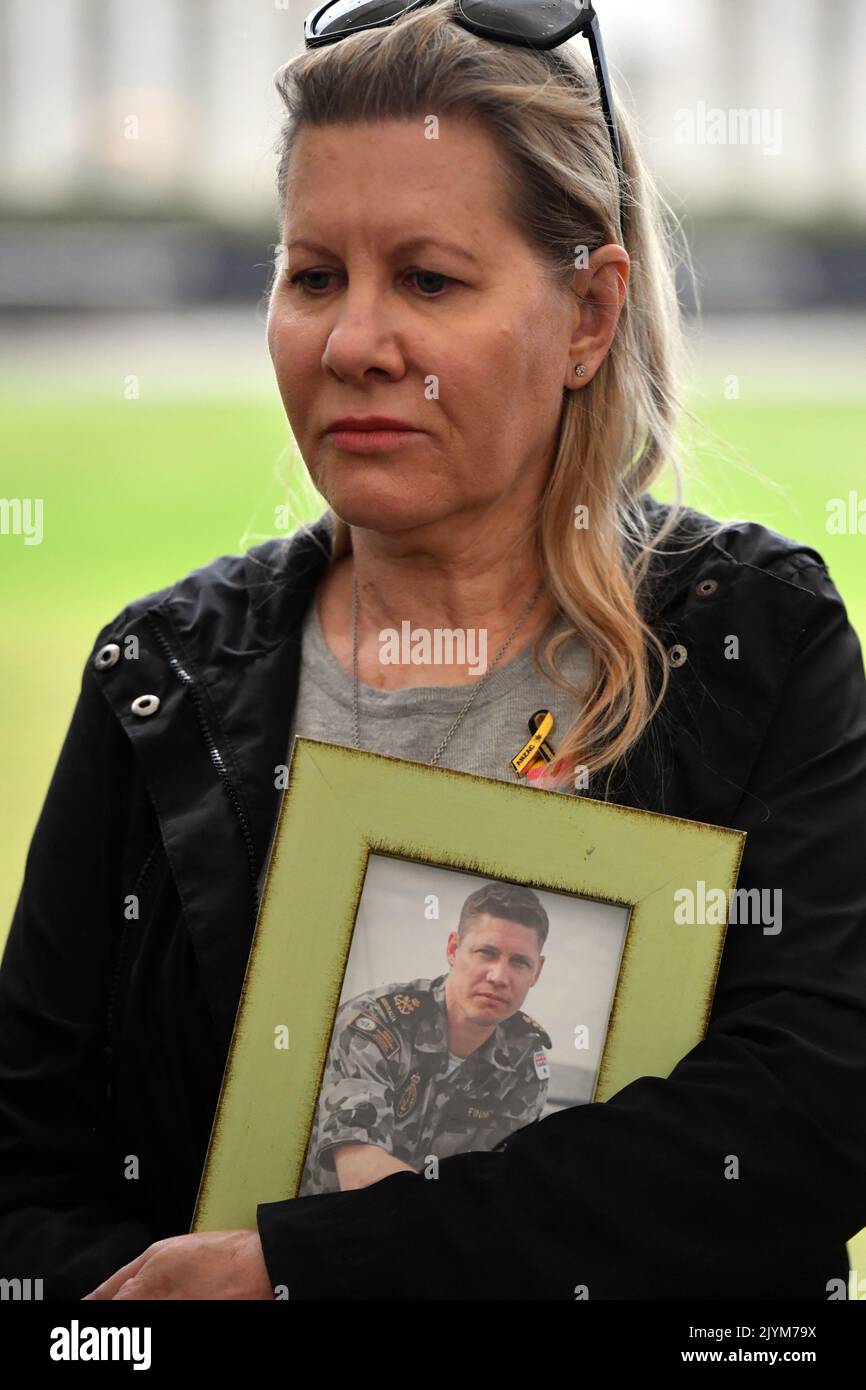 Julie-Ann Finney holds a framed photograph of her son at a rally to ...