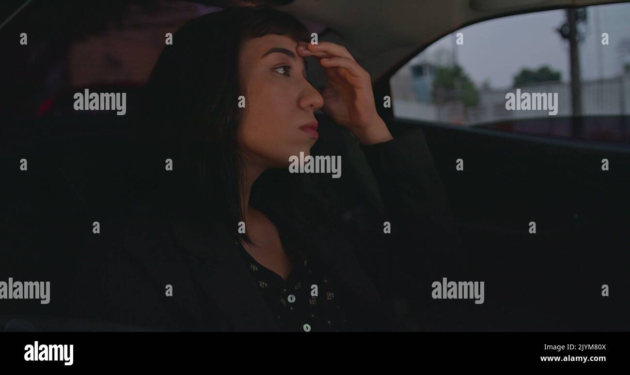 Young woman in car backseat stuck in traffic at night commuting from ...