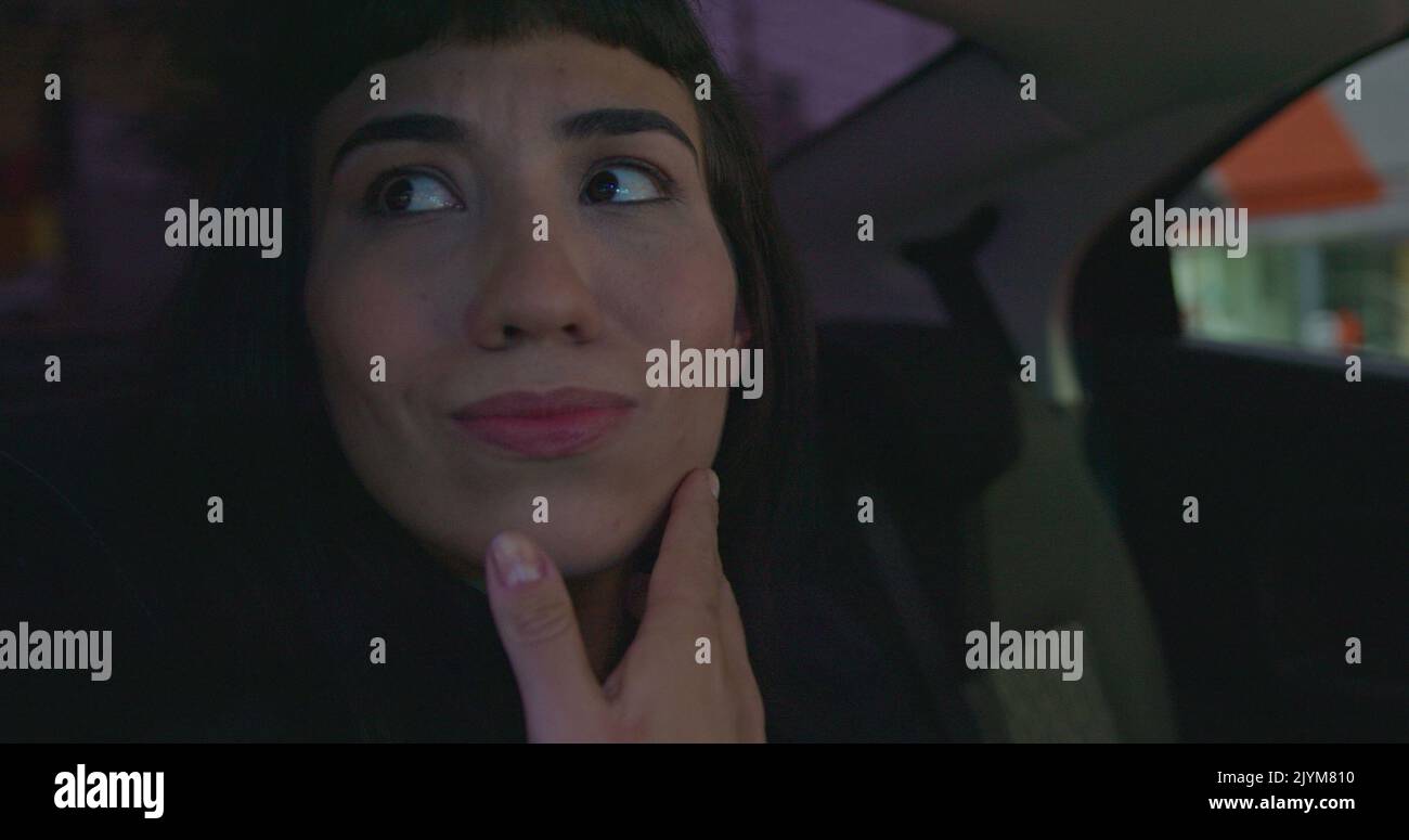 Young woman in car backseat stuck in traffic at night commuting from ...