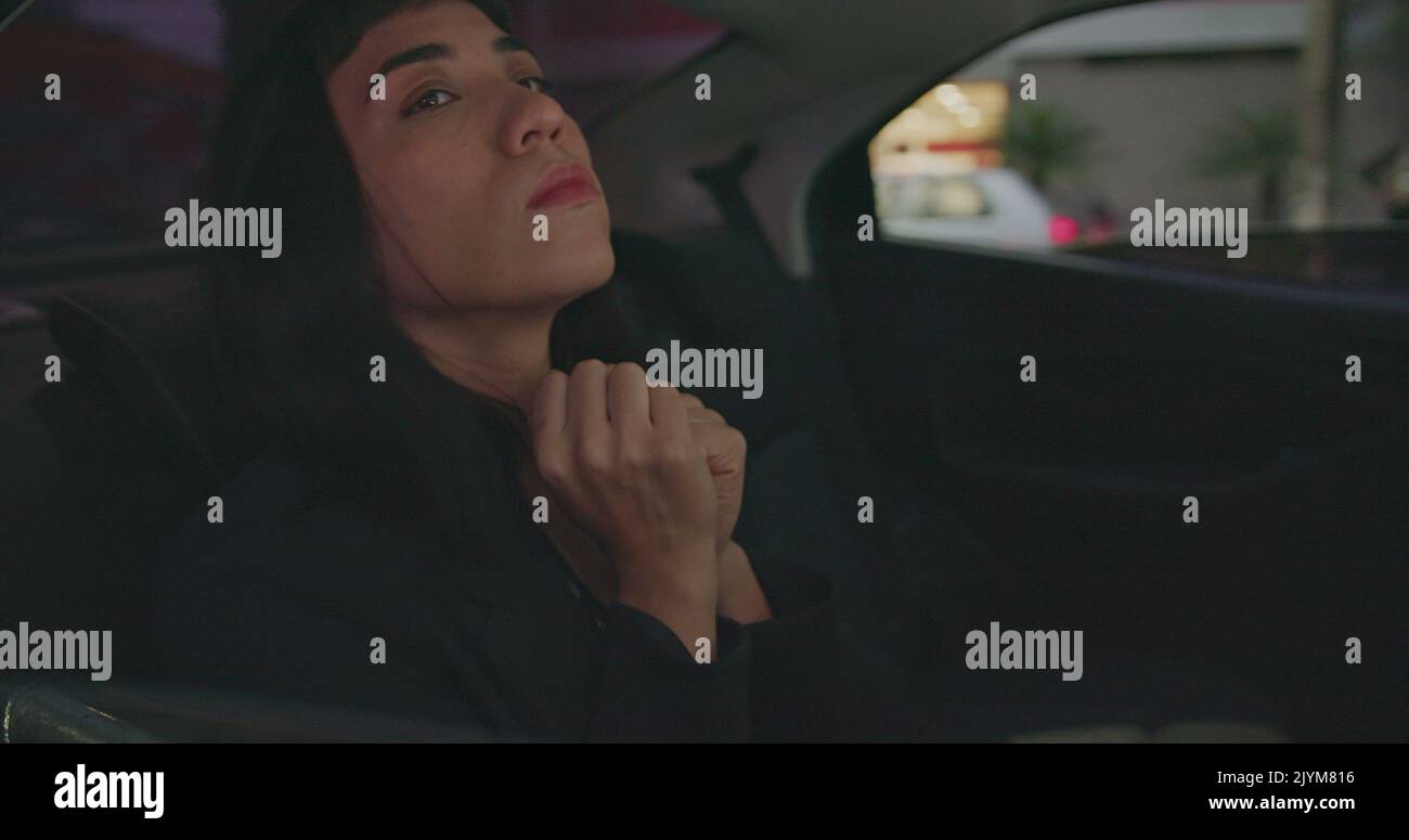 Young woman in car backseat stuck in traffic at night commuting from ...