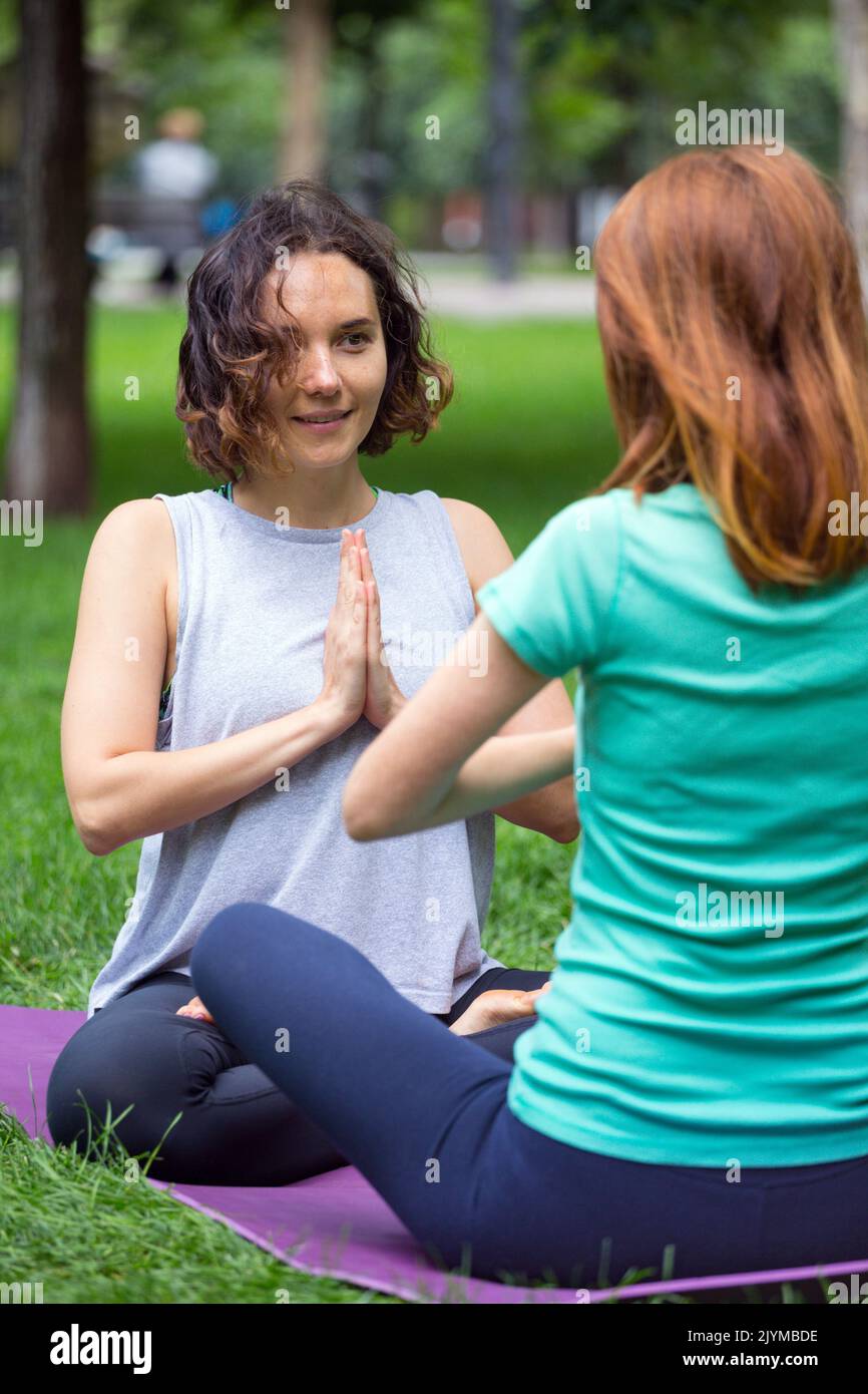 Happy girls doing yoga in the park on the grass. Healthy and Yoga ...