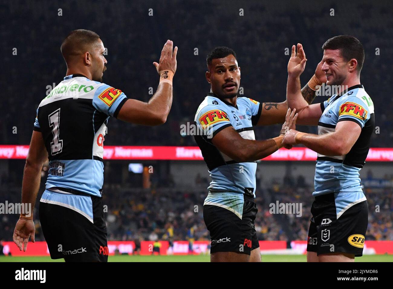 Sione Katoa of the Sharks (centre) celebrates scoring a try during the ...