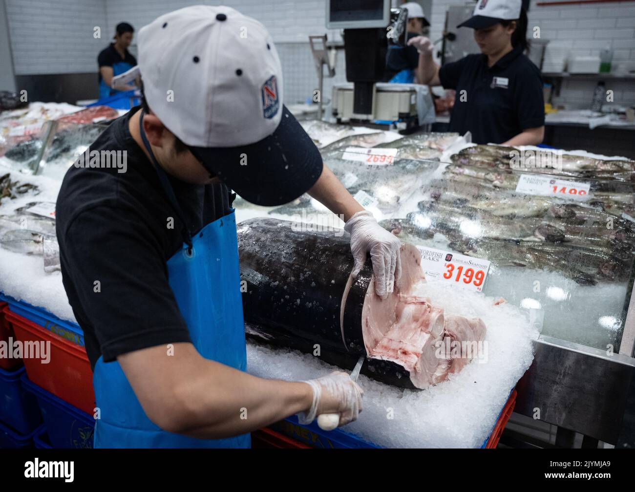 A trader cutting swordfish during Good Friday trade at the Sydney Fish ...