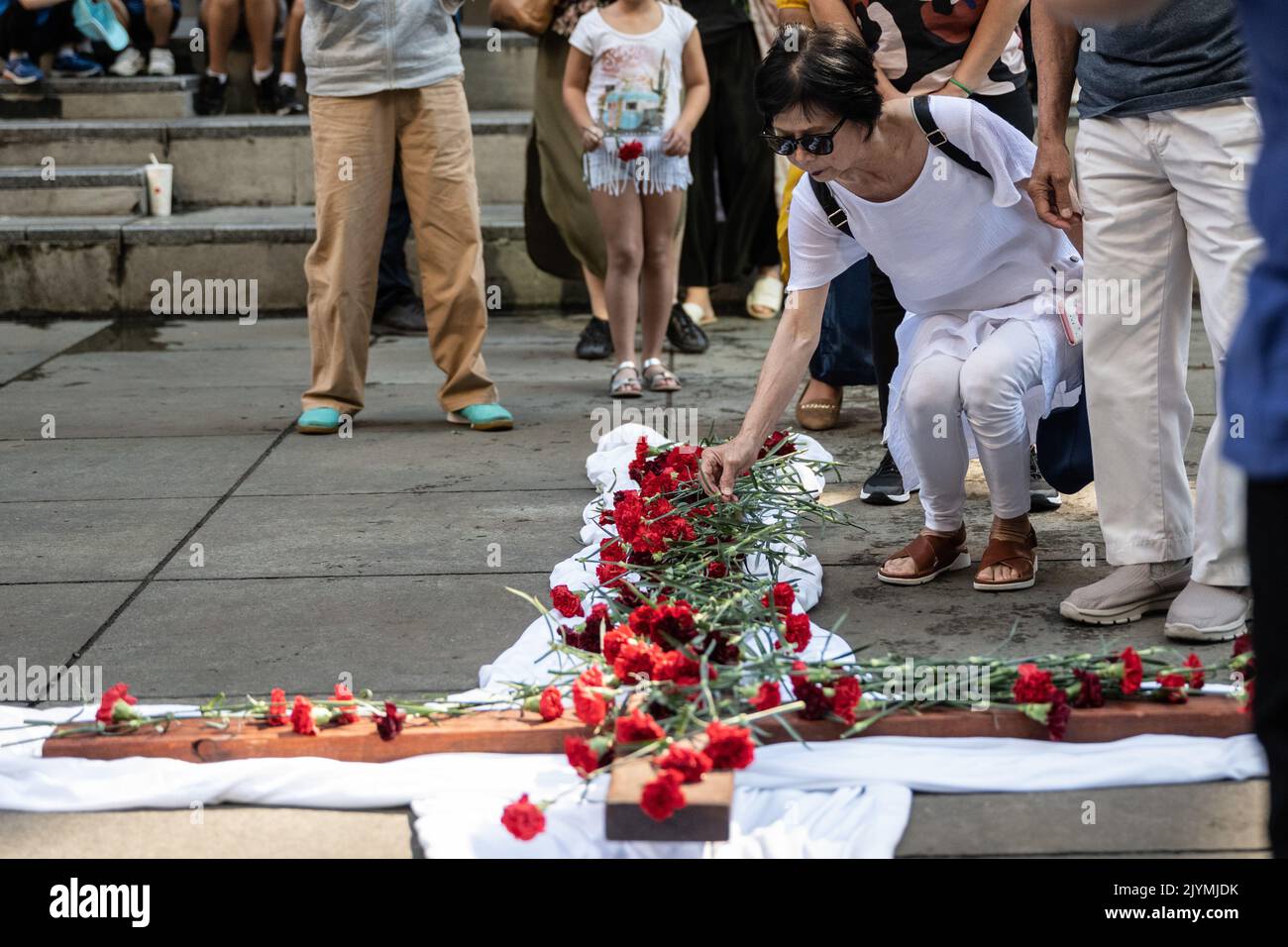 A worshipper places a carnation flower on a cross during a Good Friday ...