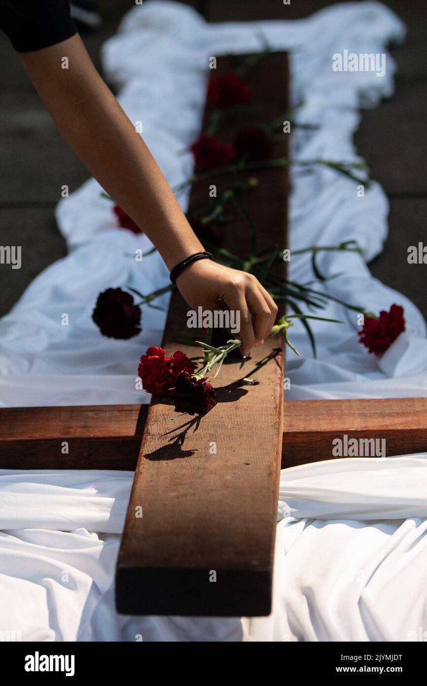 A worshipper places a carnation flower on a cross during a Good Friday ...