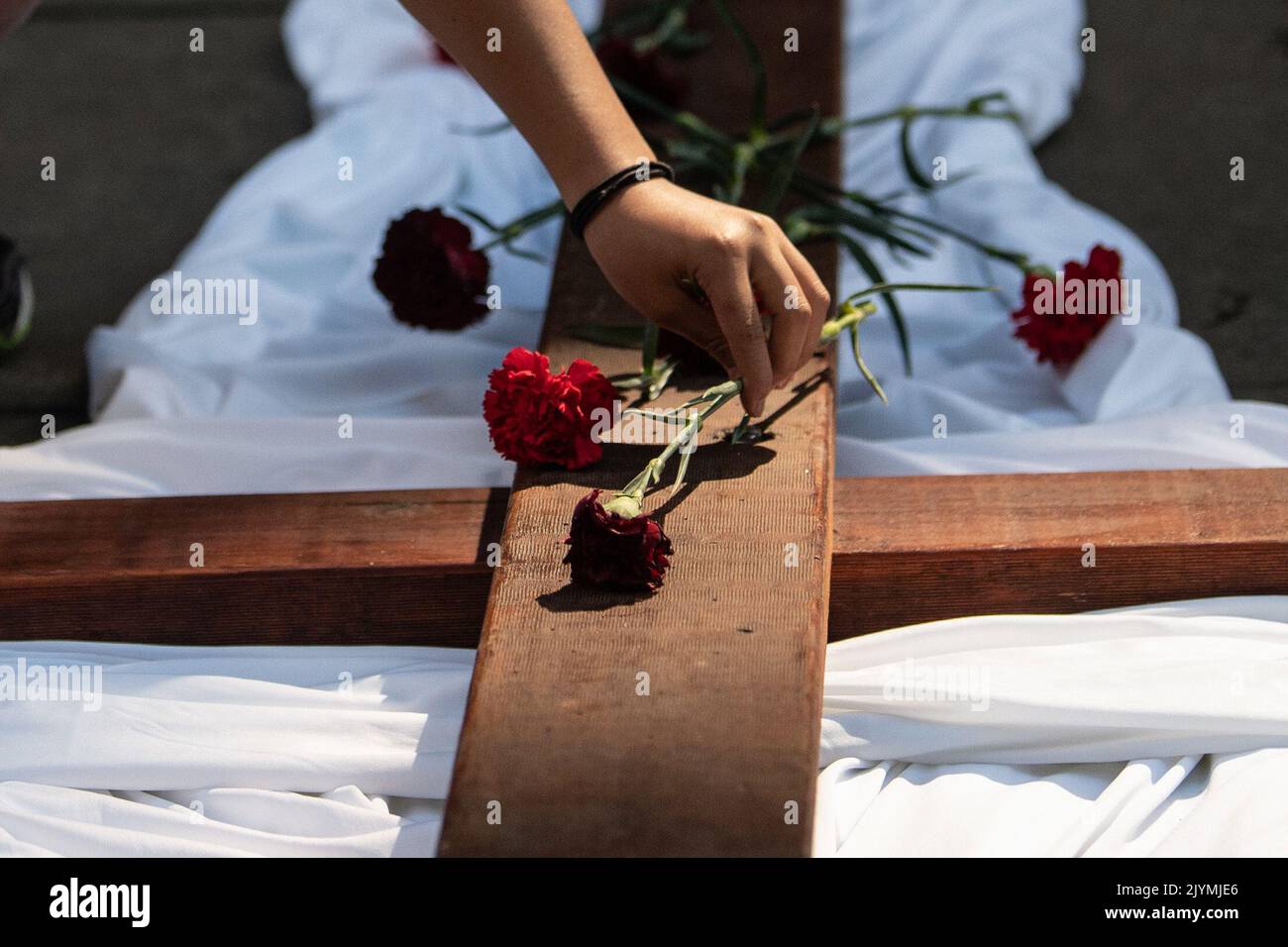 A worshipper places a carnation flower on a cross during a Good Friday ...