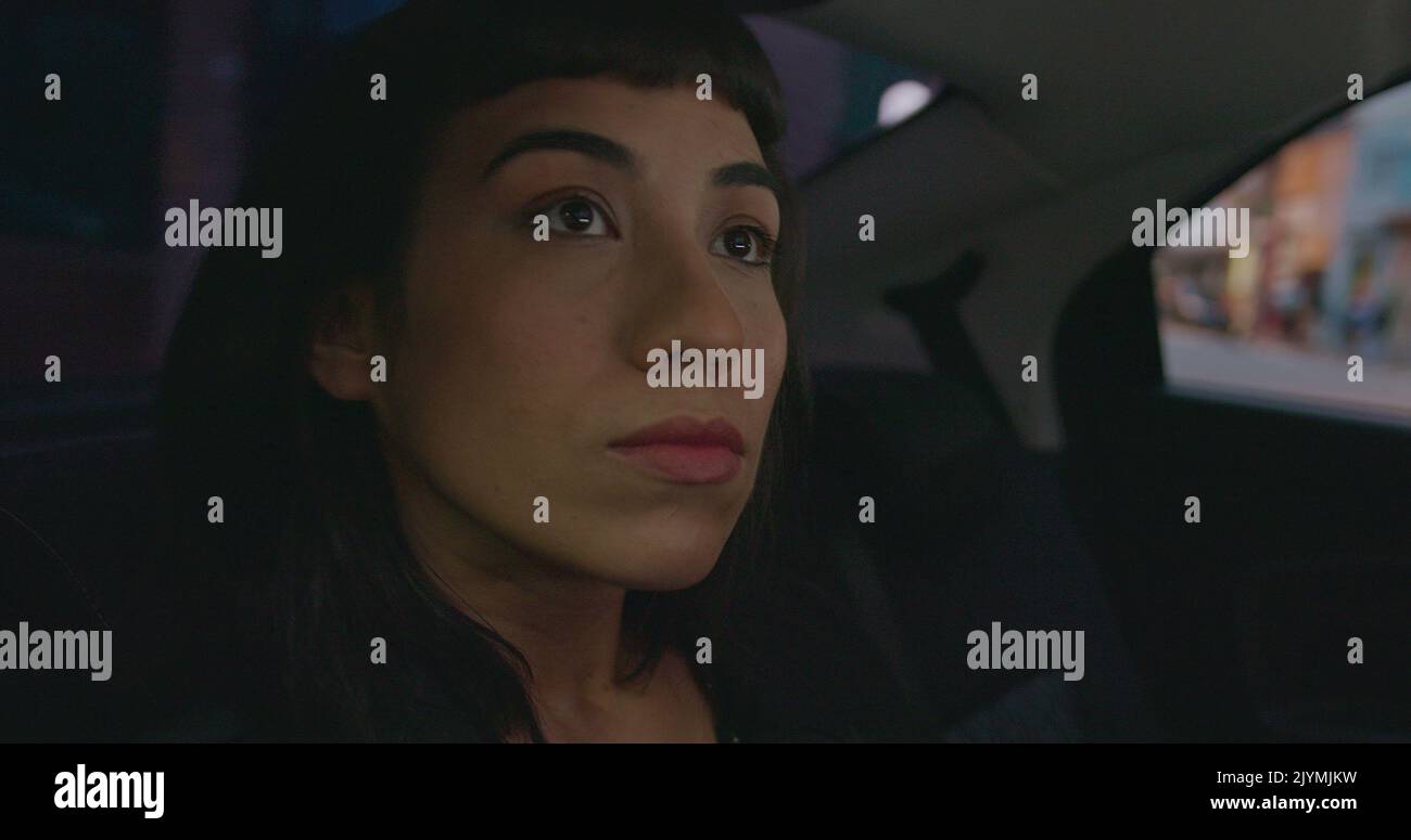 One happy hispanic woman in car backseat looking out vehicle window ...