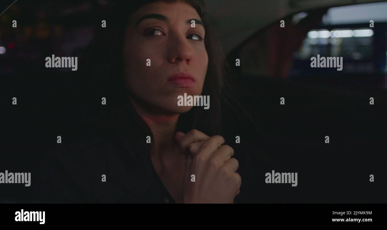 Anxious female passenger late for meeting in the backseat of a car ...