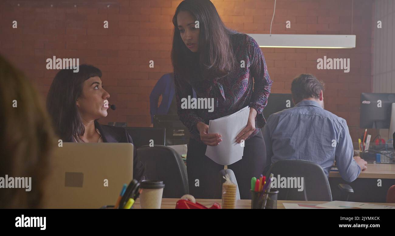 Group of young employees working at office at night. Staff at work in ...