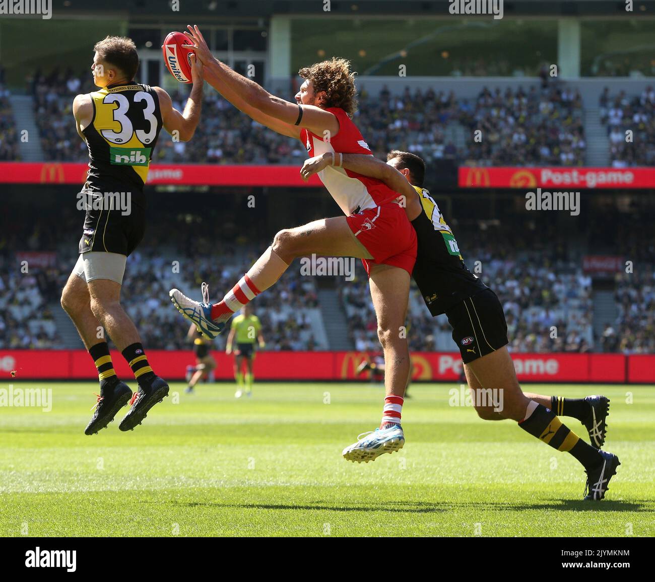 Tom Hickey of the Swans (centre) contests with Kamdyn McIntosh of the ...