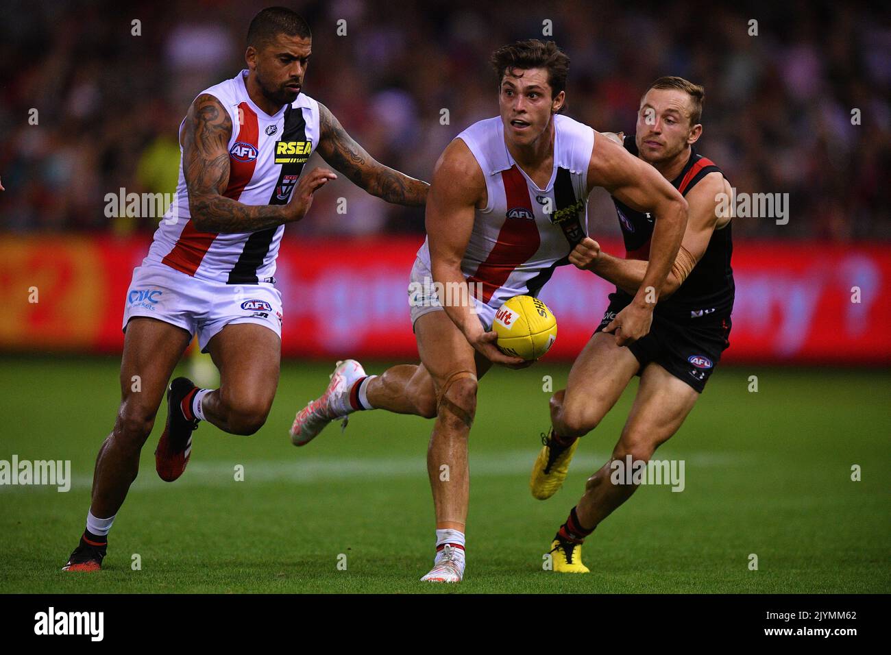 Jack Steele of St Kilda (centre) and Devon Smith (right) of Essendon Bombers in action during ...
