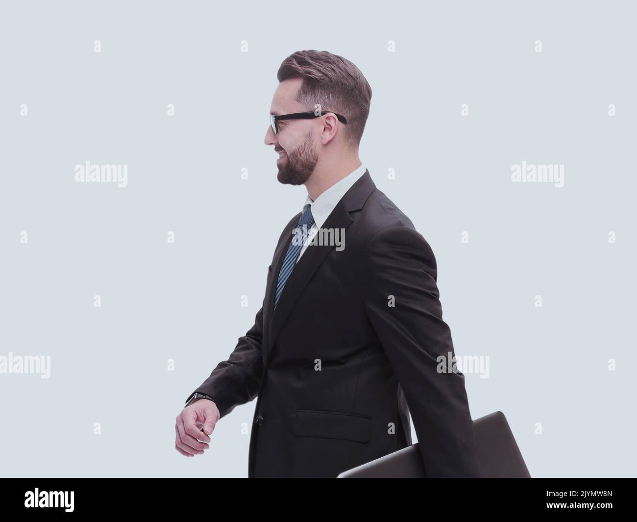 in full growth. successful businessman with laptop stepping forward ...