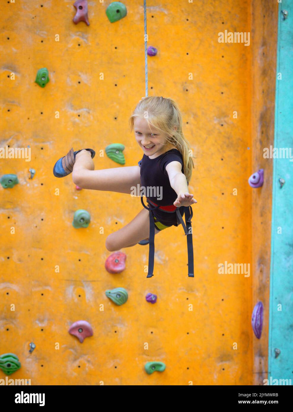 fun sport. bouldering, little smiling girl climbing up the wall Stock ...