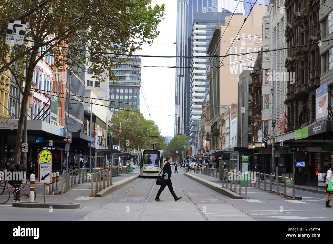 An office worker is seen crossing Elizabeth Street at the intersection ...