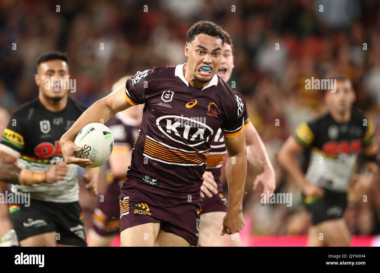 Xavier Coates of the Broncos breaks through the Panthers defence during ...