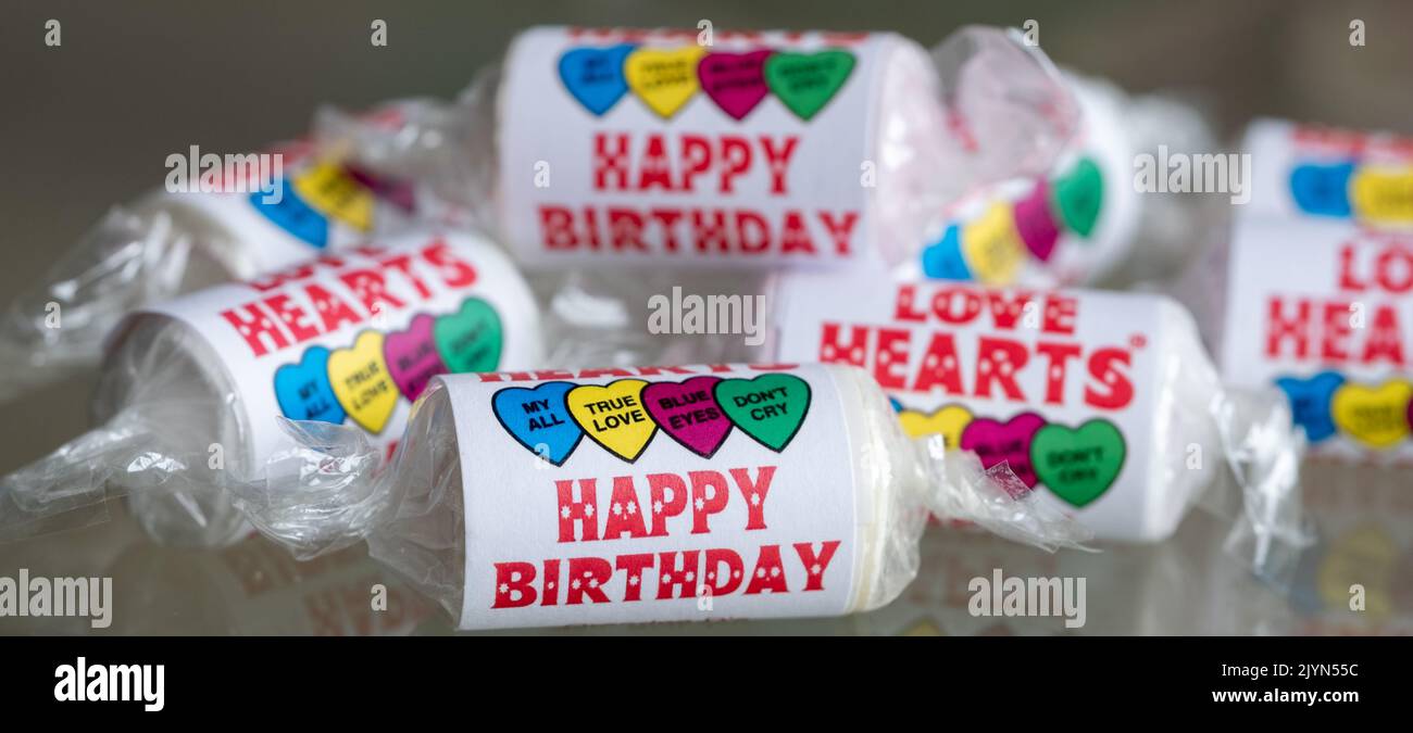 Macro photo of rolls of Swizzel's Love Heart sweets inscribed with the ...