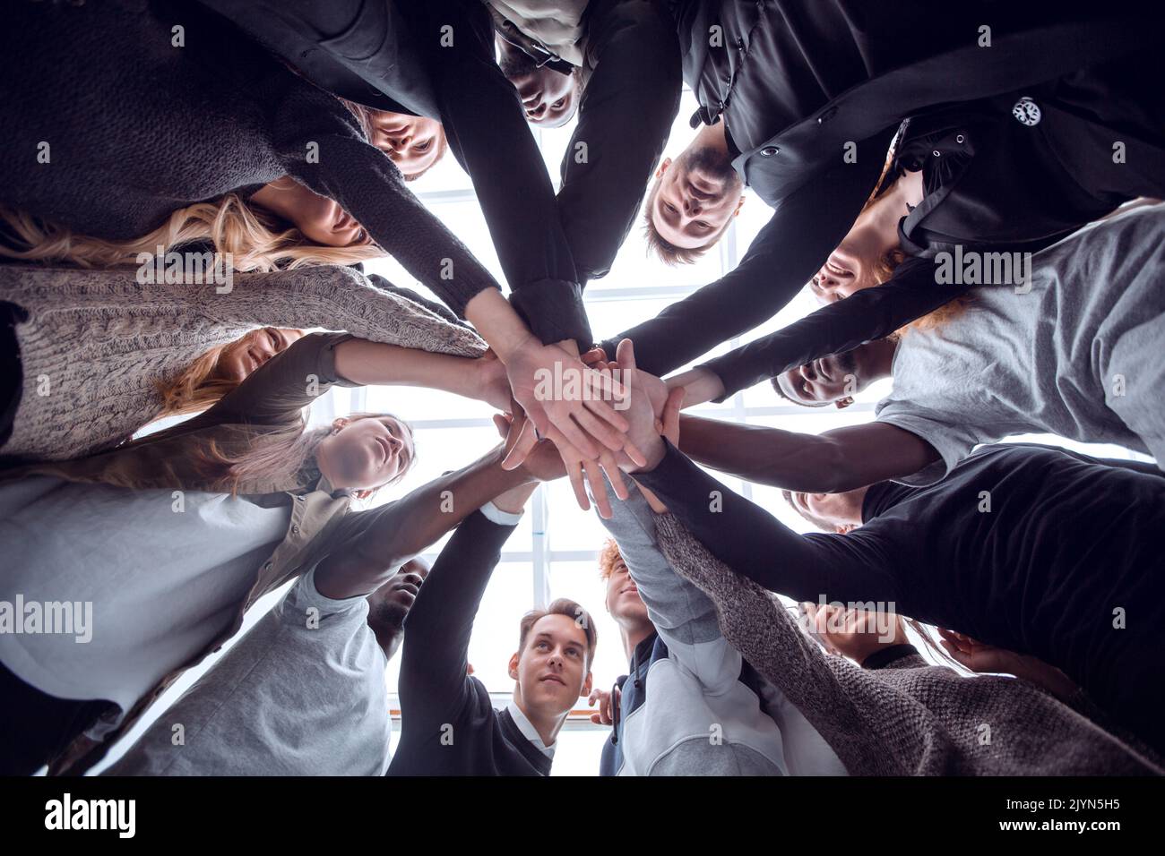 bottom view. group of happy young people making a tower out of their ...