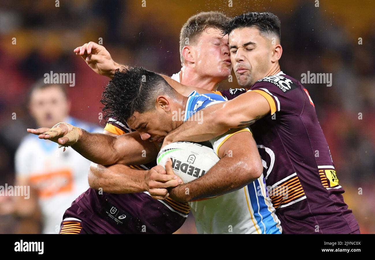 Brian Kelly (left) of the Titans is tackled by Rhys Kennedy (centre ...