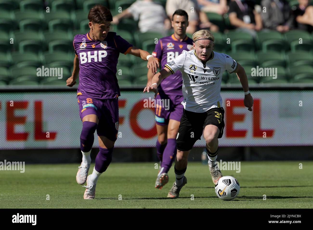Lachlan Rose of Macarthur and Kosuke Ota of the Glory compete for the ...