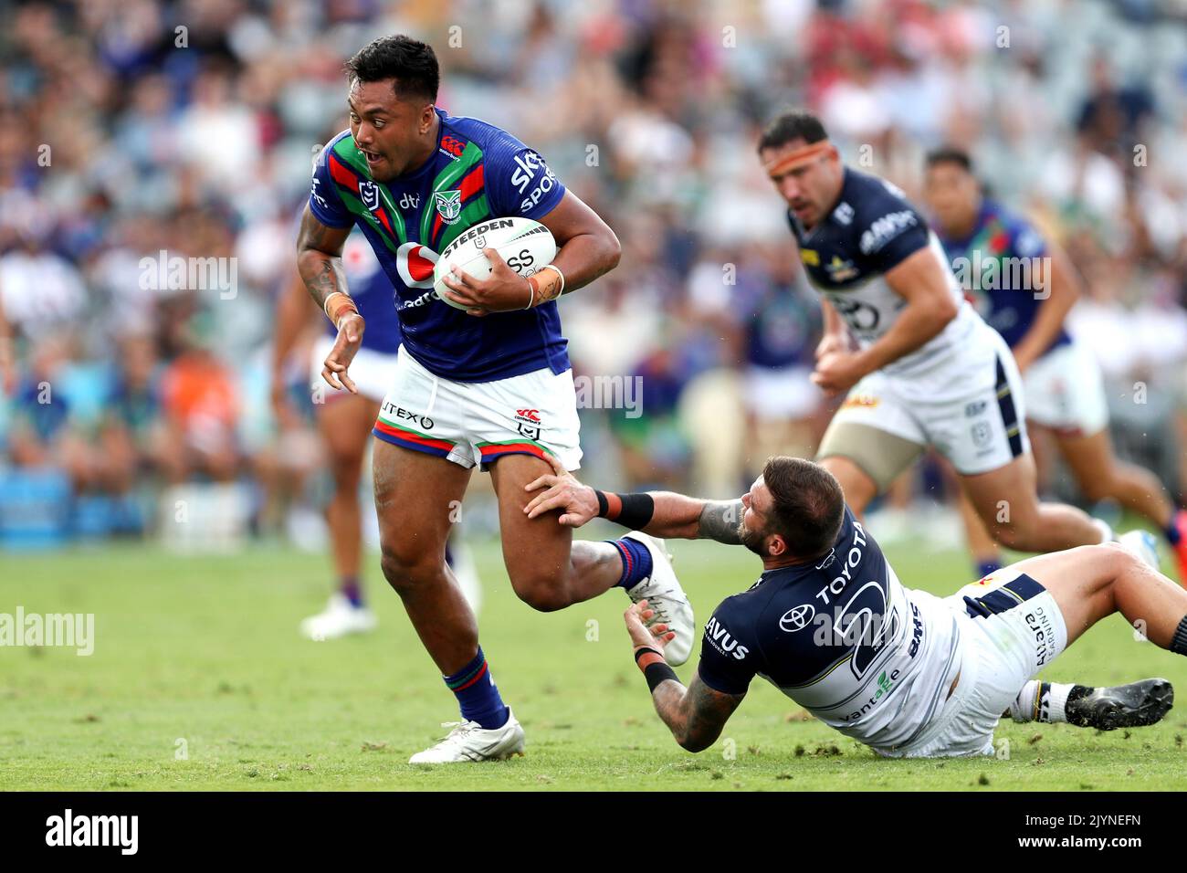 Adam Pompey of the Warriors breaks the tackle of Kyle Feldt of the ...