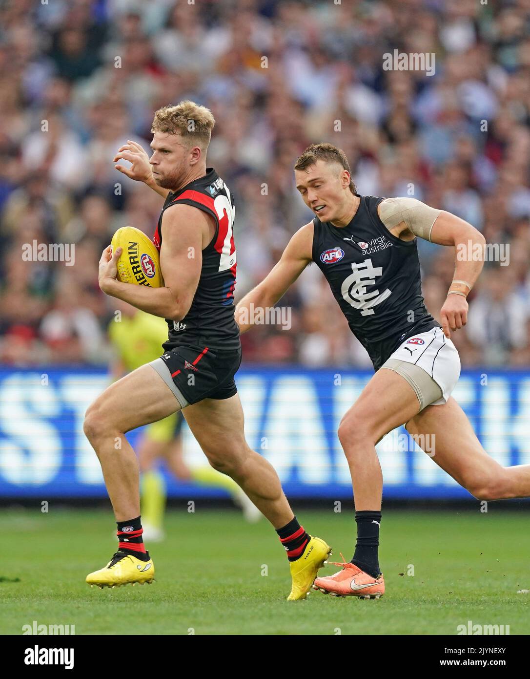 Jake Stringer of the Bombers runs away from Patrick Cripps of the Blues ...
