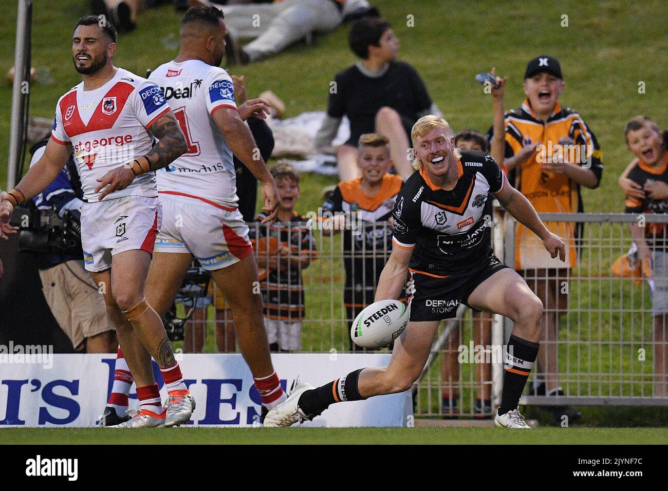 Zac Cini of the Tigers celebrates after scoring a try on debut during ...