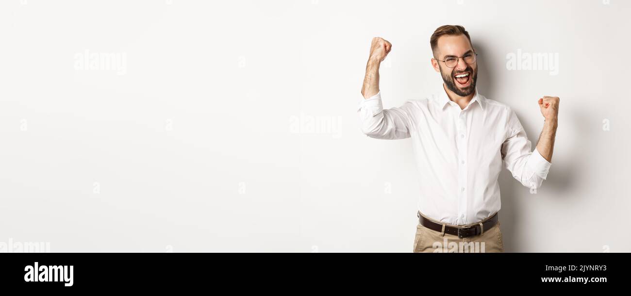 Successful businessman rejoicing, raising hands up and celebrating ...