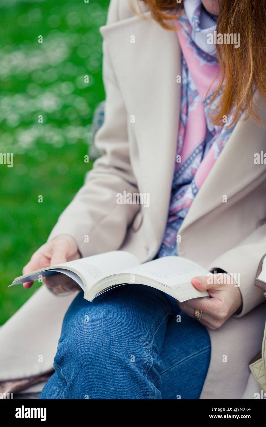 girl sitting on a bench and reading Stock Photo - Alamy