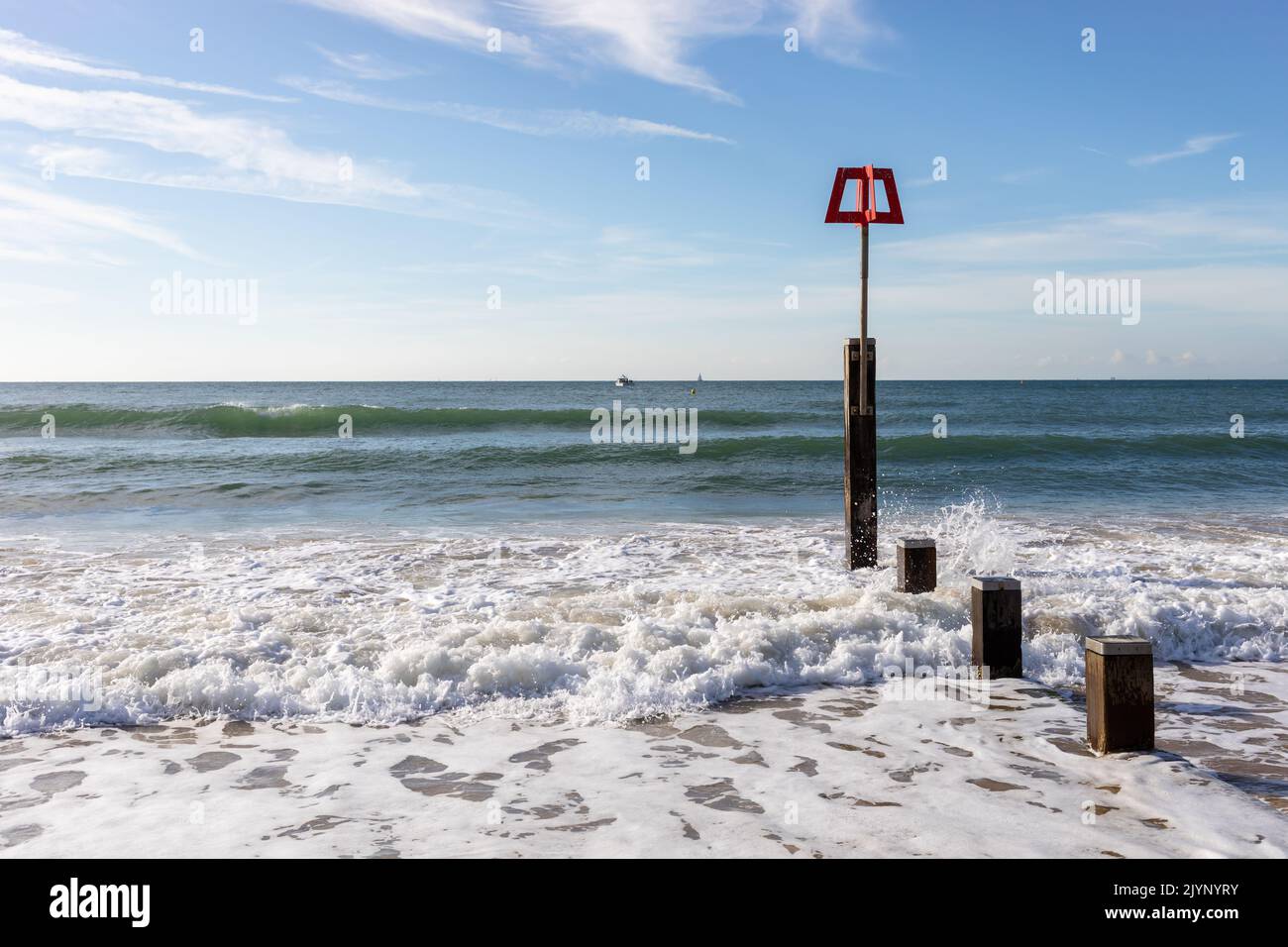 Groyne marker in the sea with splashing waves at Bournemouth beach ...