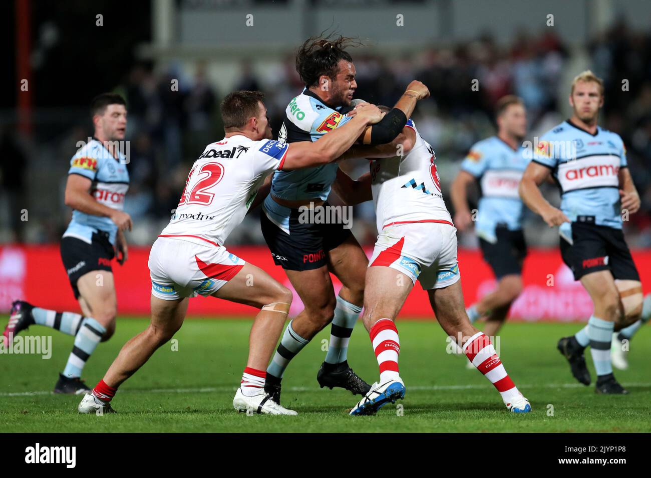 Toby Rudolf of the Sharks is tackled by the Dragons defence during the ...