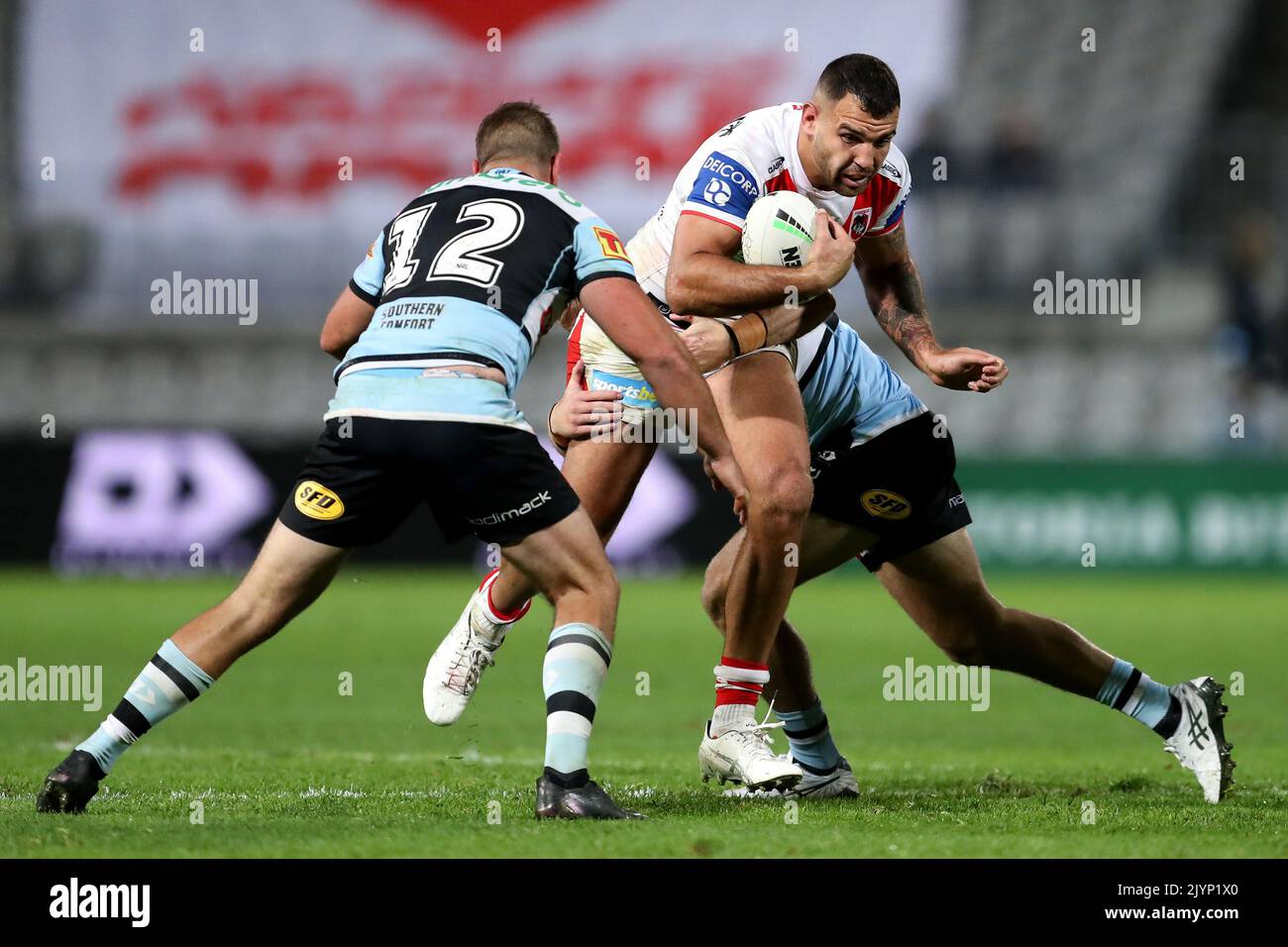 Josh Kerr of the Dragons is tackled by the Sharks defence during the ...