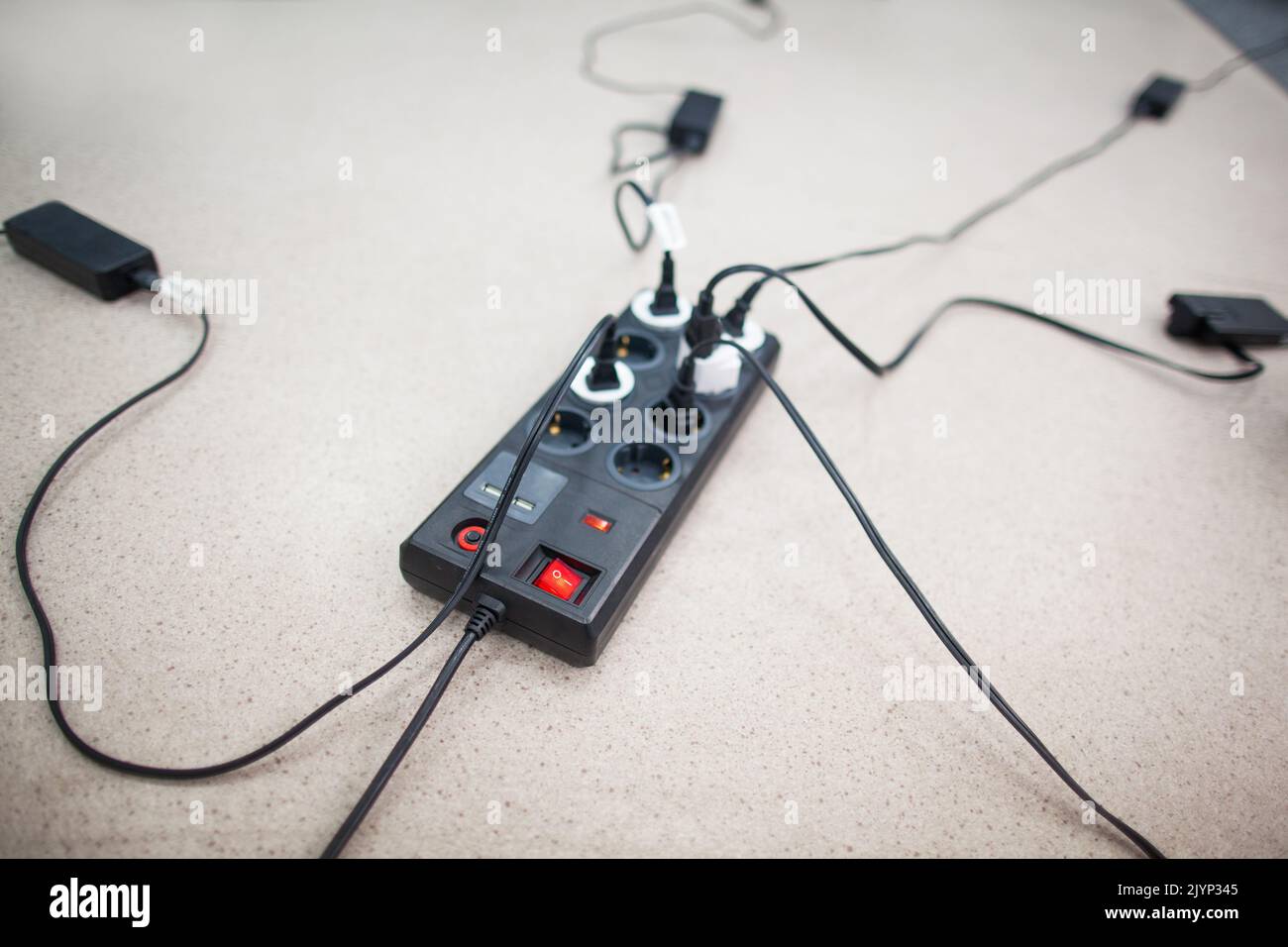 Extension cord electrical outlet which many devices Stock Photo - Alamy