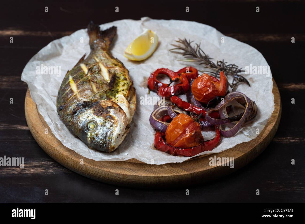 baked fish with vegetables on a plate Stock Photo - Alamy