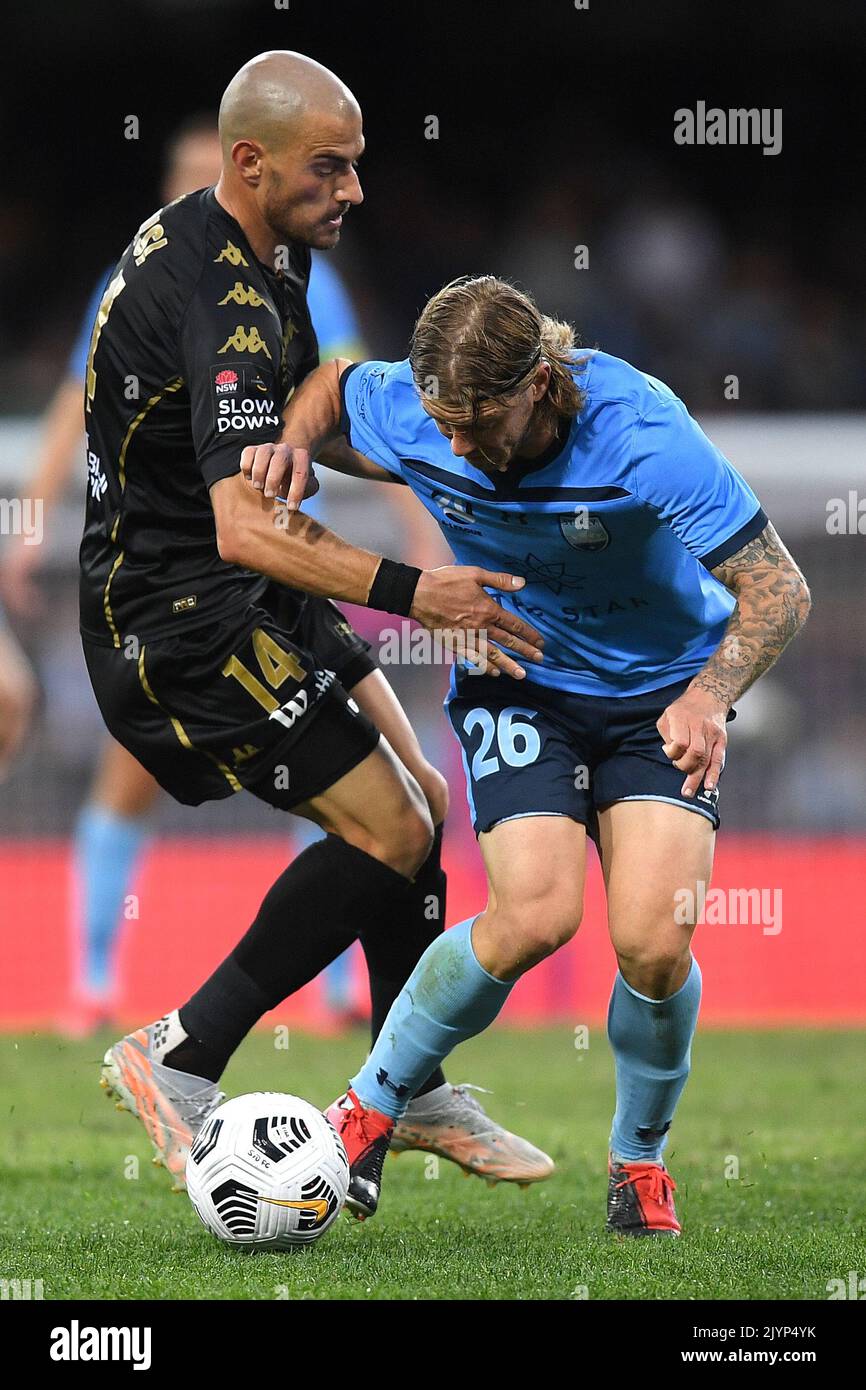 Luke Brattan of Sydney FC is tackled by James Troisi of the Wanderers ...