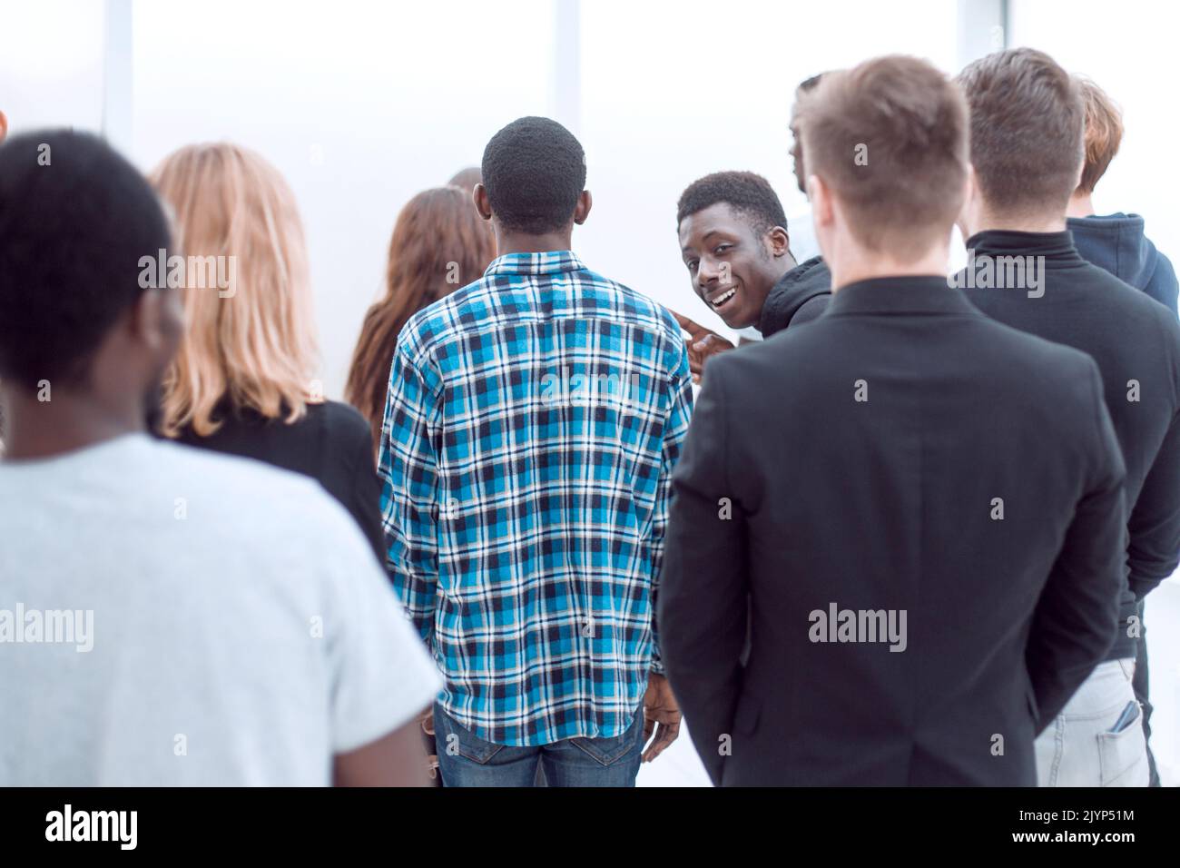 young man standing among a group of diverse young people Stock Photo ...