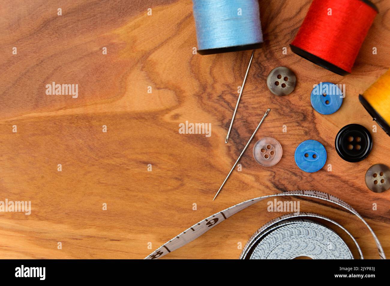 Sewing accessories and fabric on a wood background. Threads, needles ...