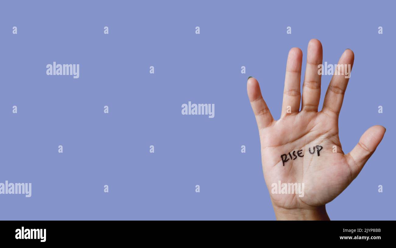 Word rise up written on hand isolated on blue background. copy space ...