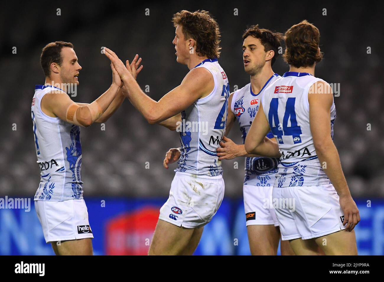 Nick Larkey of North Melbourne (centre) celebrates with team mates ...