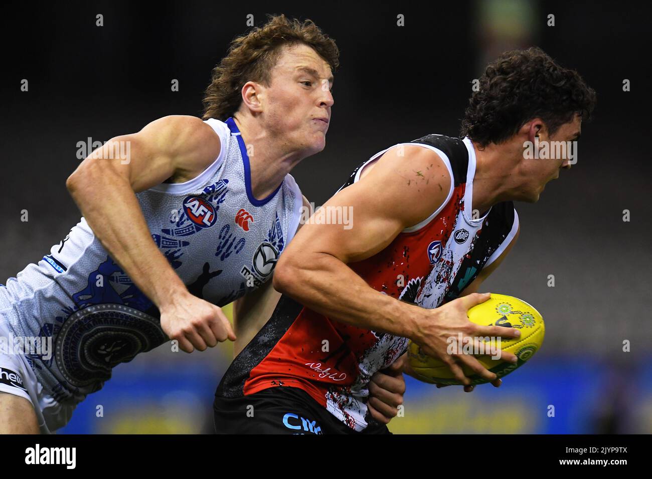 Nick Larkey of North Melbourne (left) tackles Oscar Clavarino of St ...