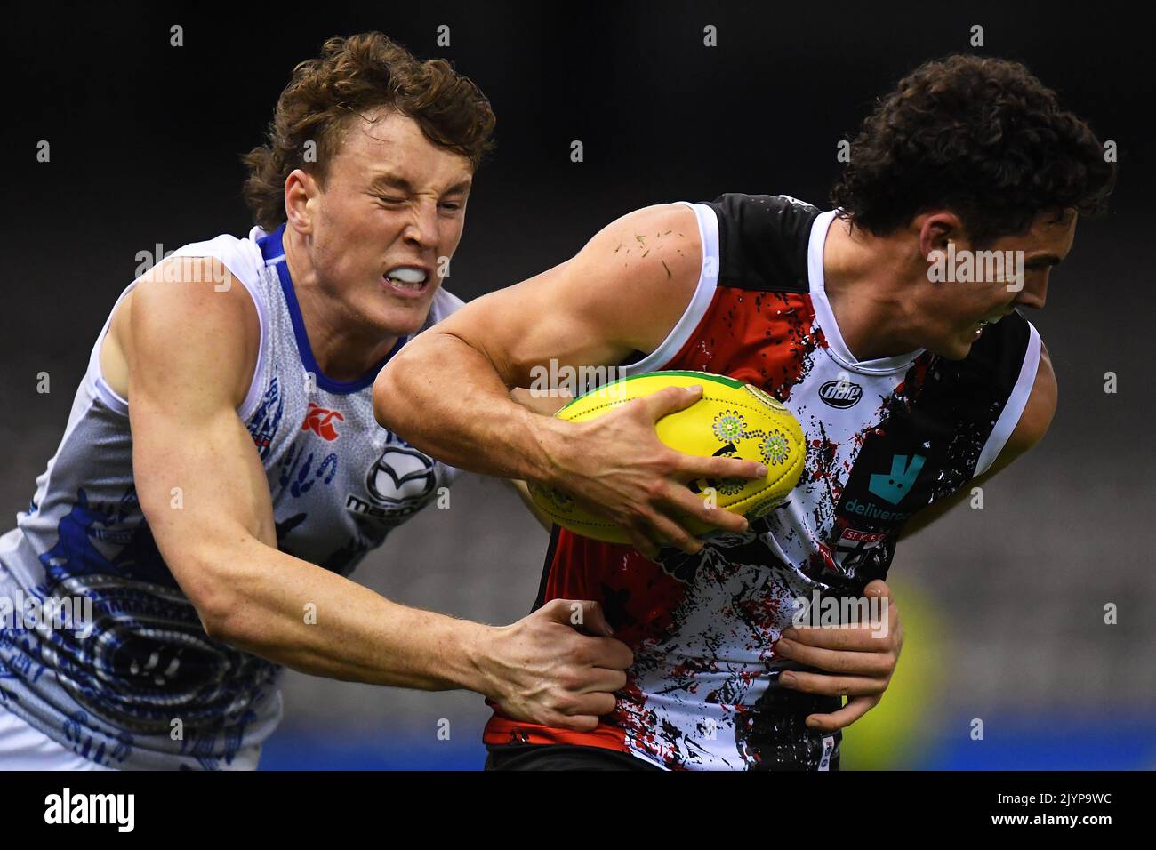 Nick Larkey of North Melbourne (left) tackles Oscar Clavarino of St ...