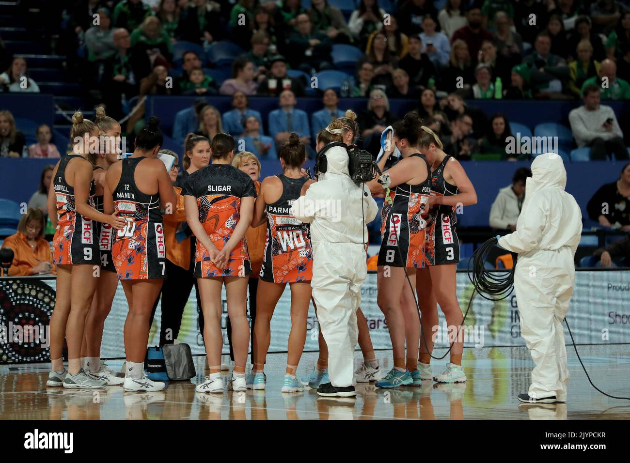 A TV camera crew in personal protective equipment (PPE) film a Giants ...