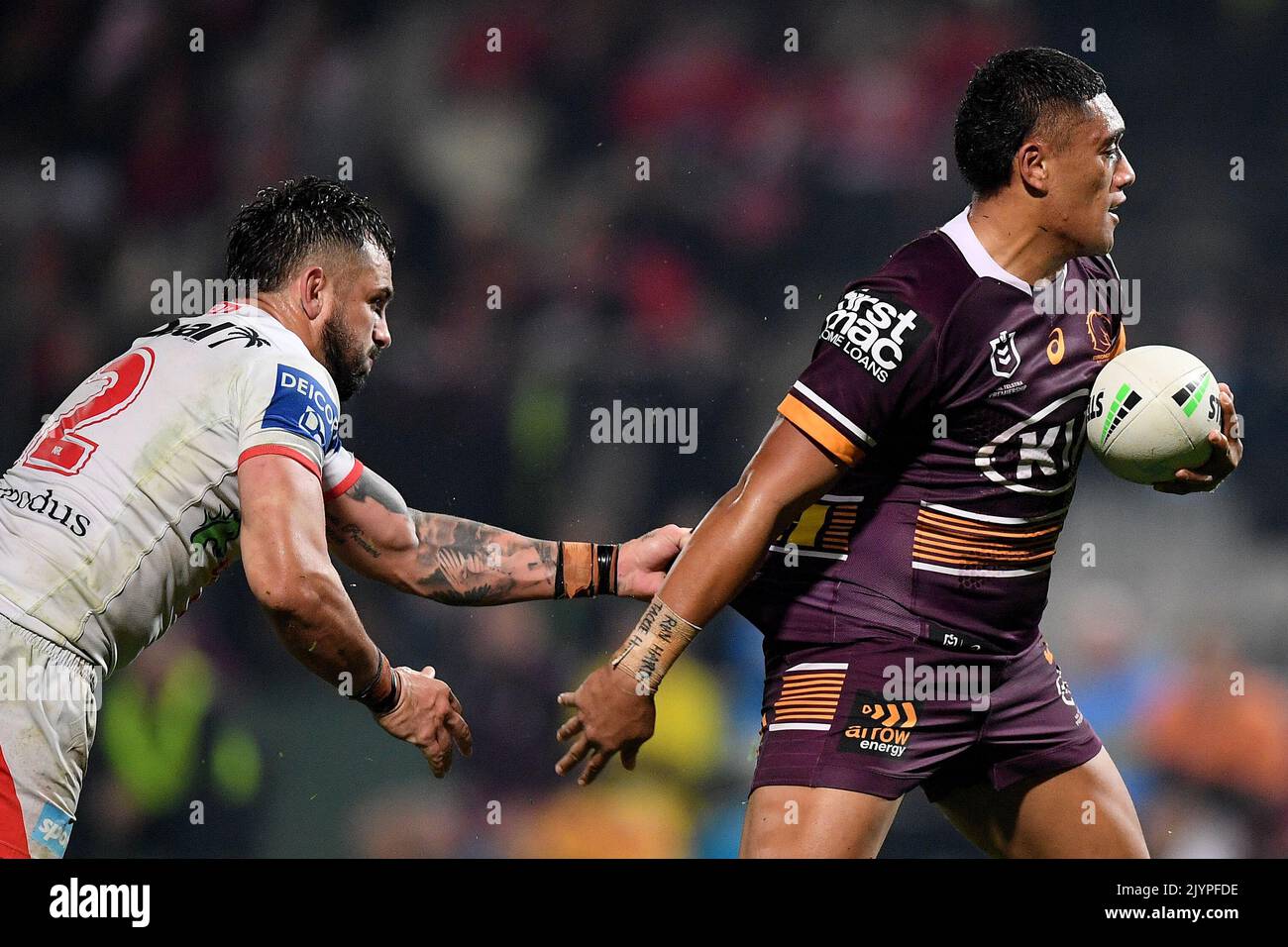 TC Robati of the Broncos evades a tackle from Jack Bird of the Dragons ...