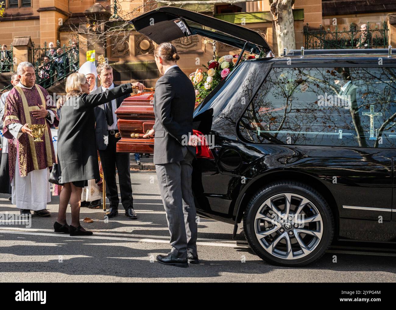 Anne Fulton brushes the casket of Bob Fulton after the State Funeral ...