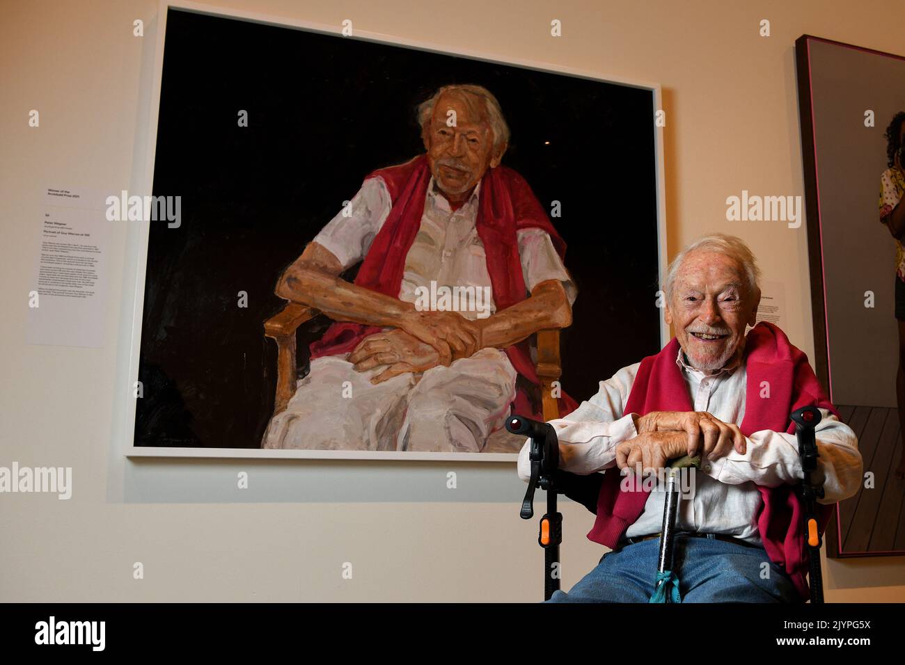Guy Warren poses for a photograph in front of his portrait by artist ...