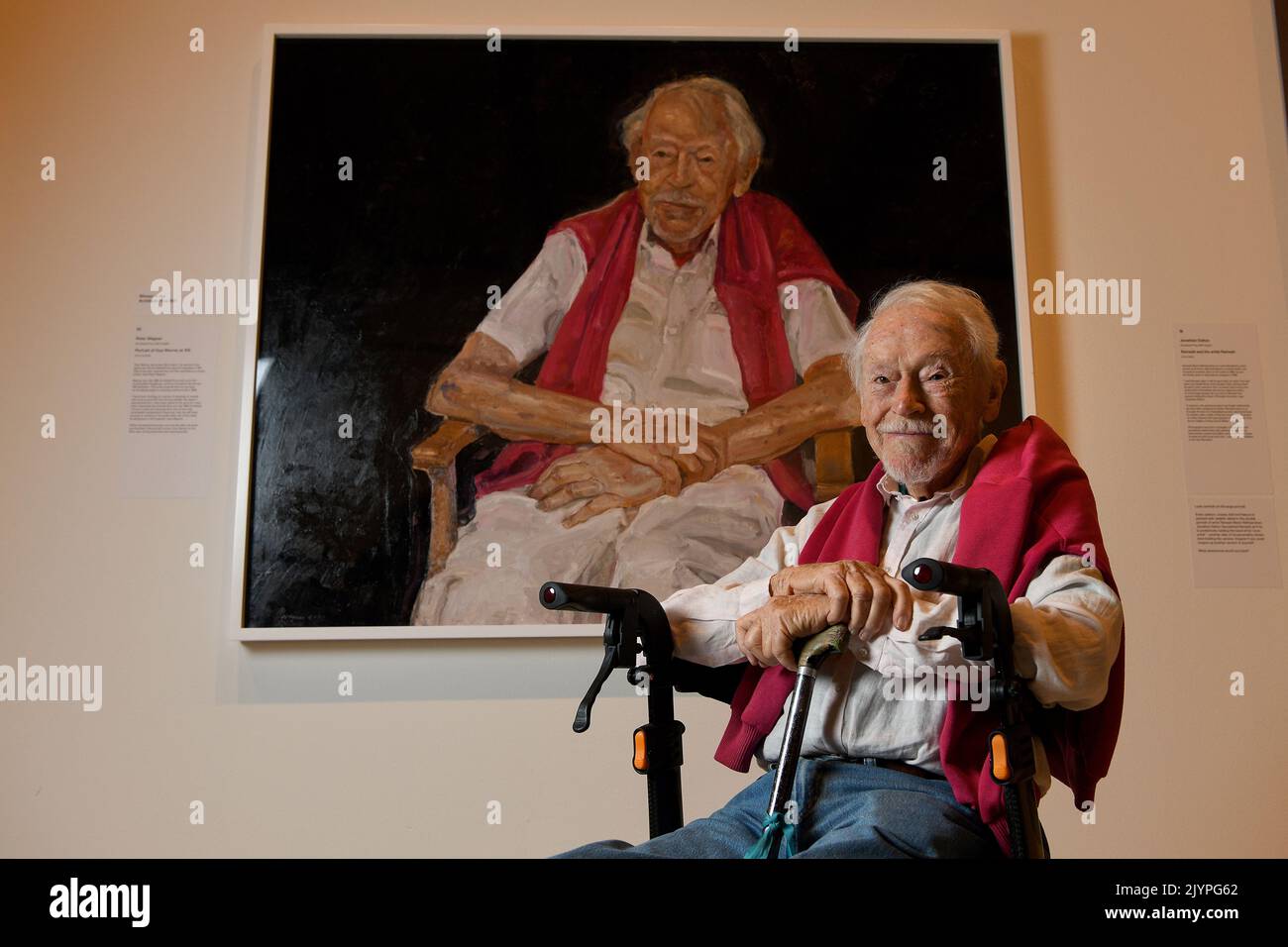 Guy Warren poses for a photograph in front of his portrait by artist ...