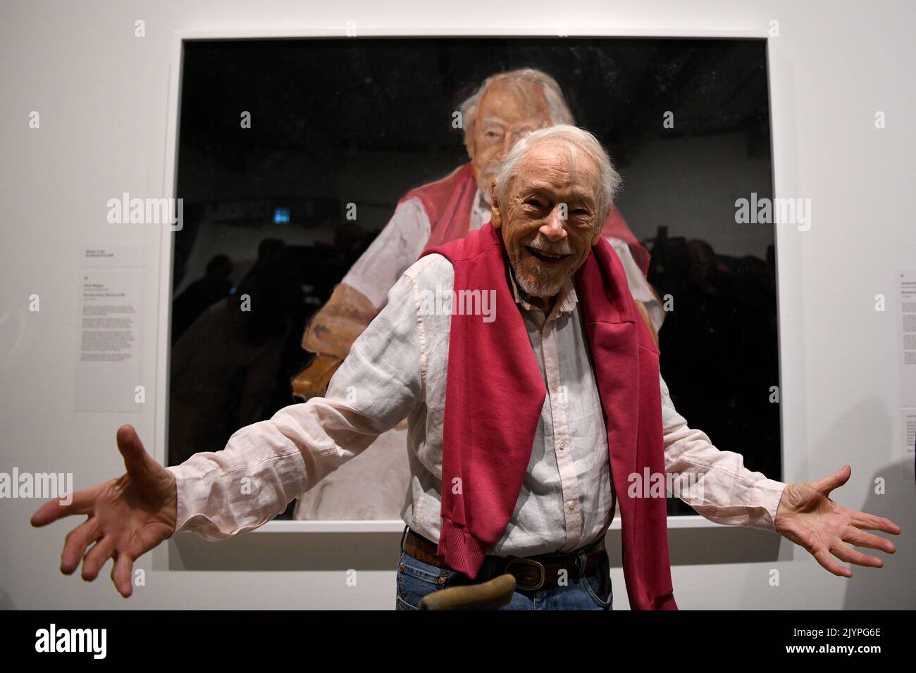 Guy Warren poses for a photograph in front of his portrait by artist ...