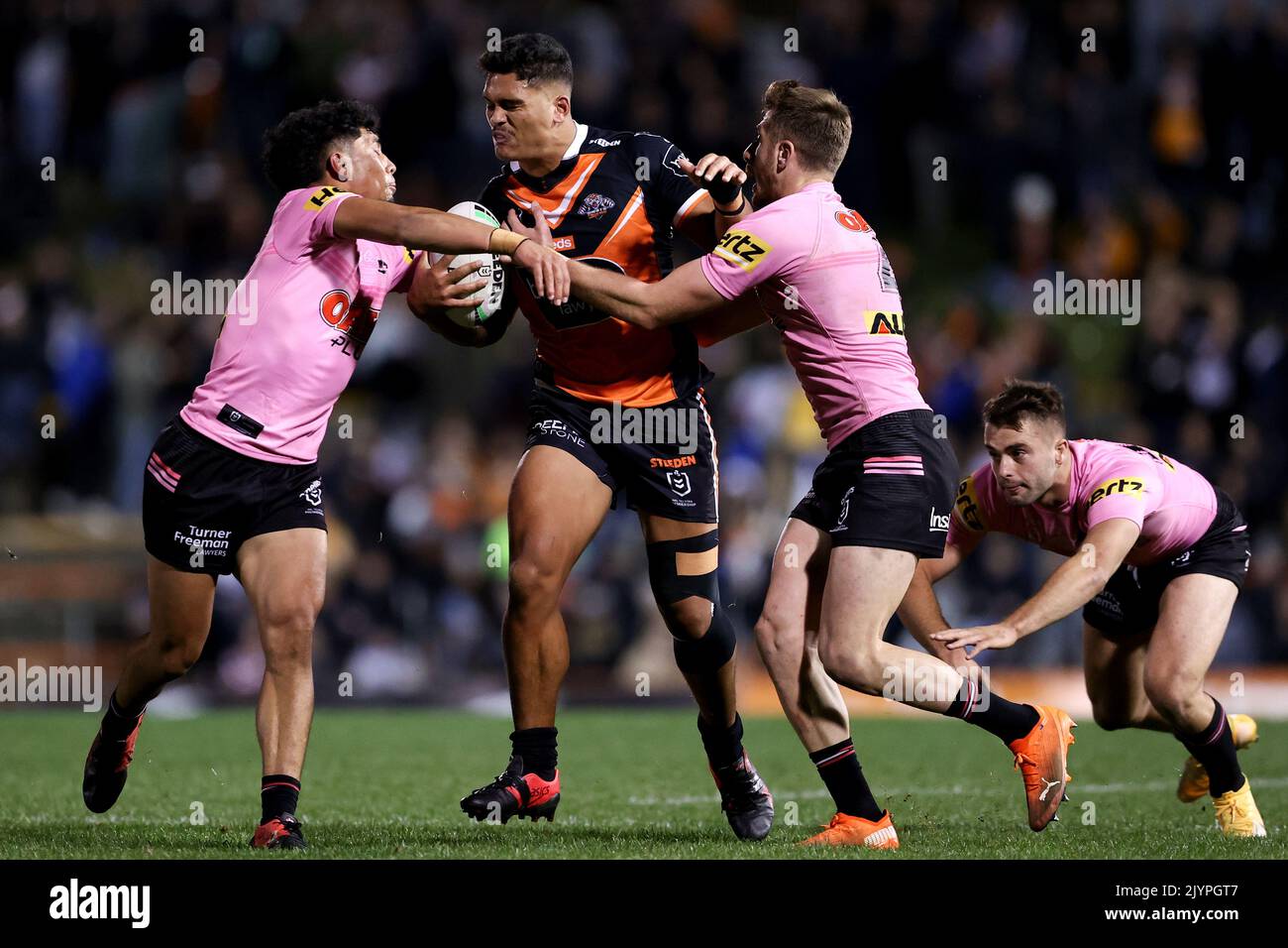 Tom Amone of the Tigers is tackled by the Panthers defence during the ...