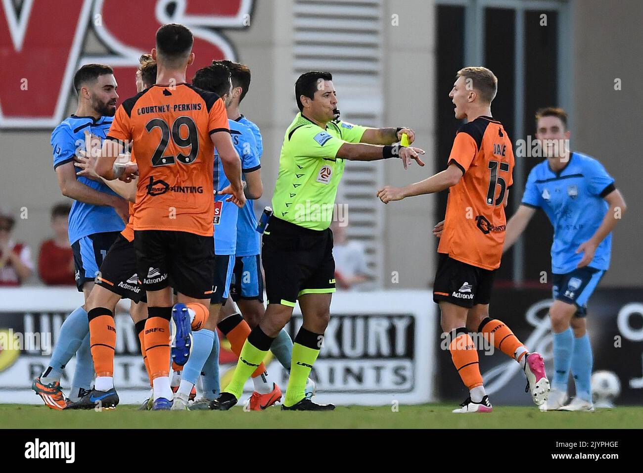Jesse Daley of the Roar (2nd right) is shown a yellow card by referee ...
